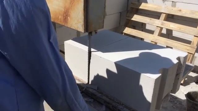 Распил газобетонного блока станком на строительном объекте.