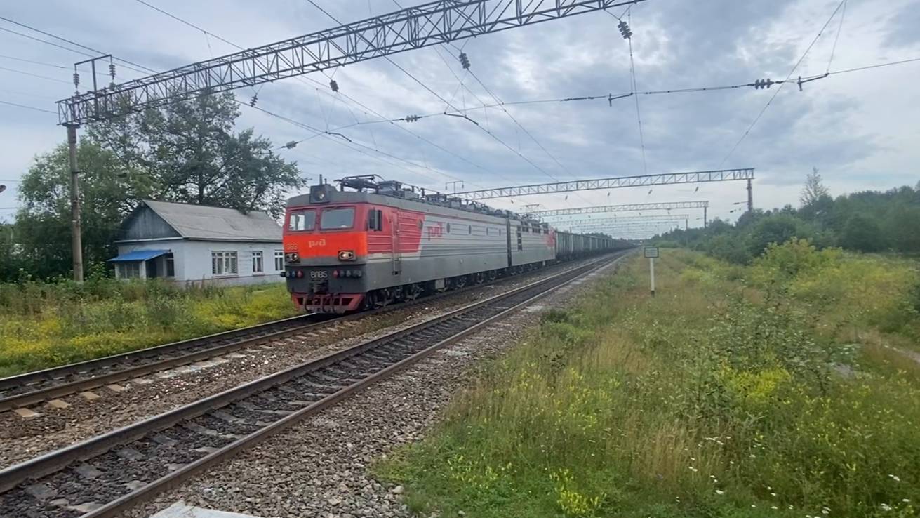 ВЛ85-063 с грузовым поездом следует через о.п. Мурино ВСЖД. Дата съемки: 02.08.2025