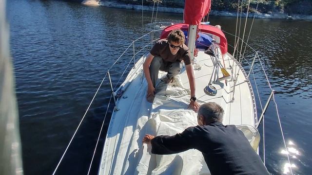 Складывание спинакера на стоянке у острова на лодке