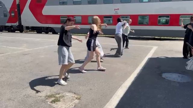 Коллектив девушек танцует на железнодорожной платформе