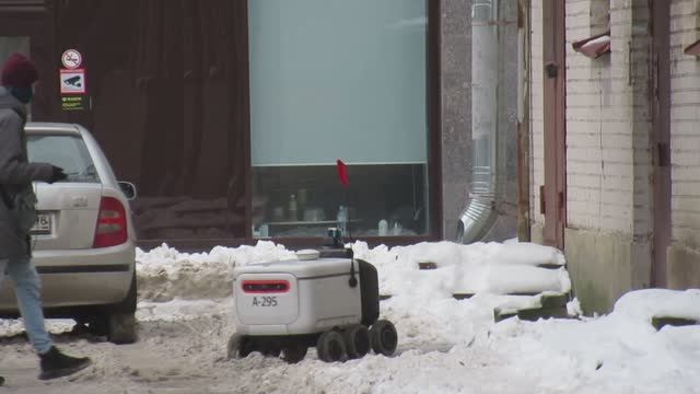 Мужик выгуливает робота. Робот буксует в снегу