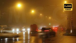 Street lights of city in fog and cars on way.