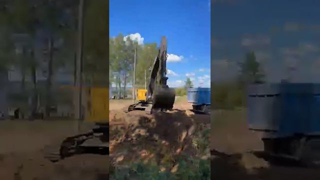 Гусеничный экскаватор, каток и самосвал на строительной площадке