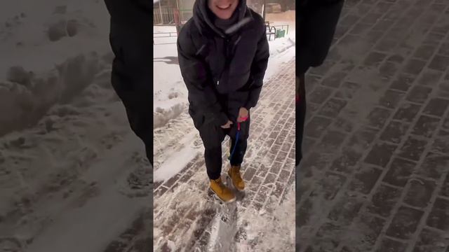 Кошка прячется от снега к хозяйке под пуховик