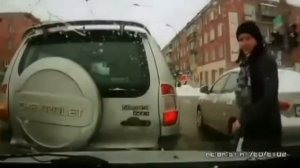 Женщина бьет рукой по капоту остановившейся машины