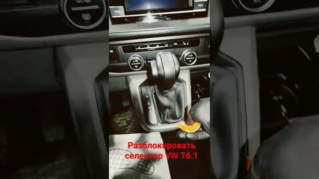 разблокировать селектор, сняв чехол рукоятки КПП на VW T6.1